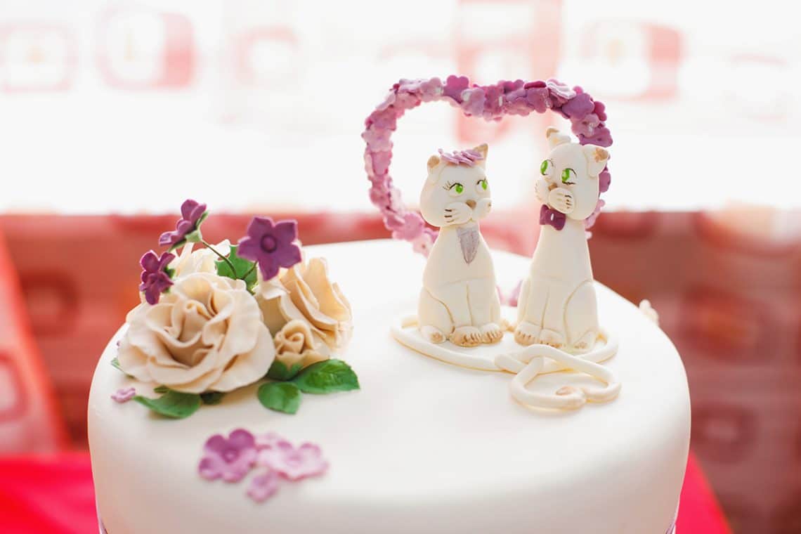 Wedding mastic cake decorated with flowers and cat figures, closeup ...